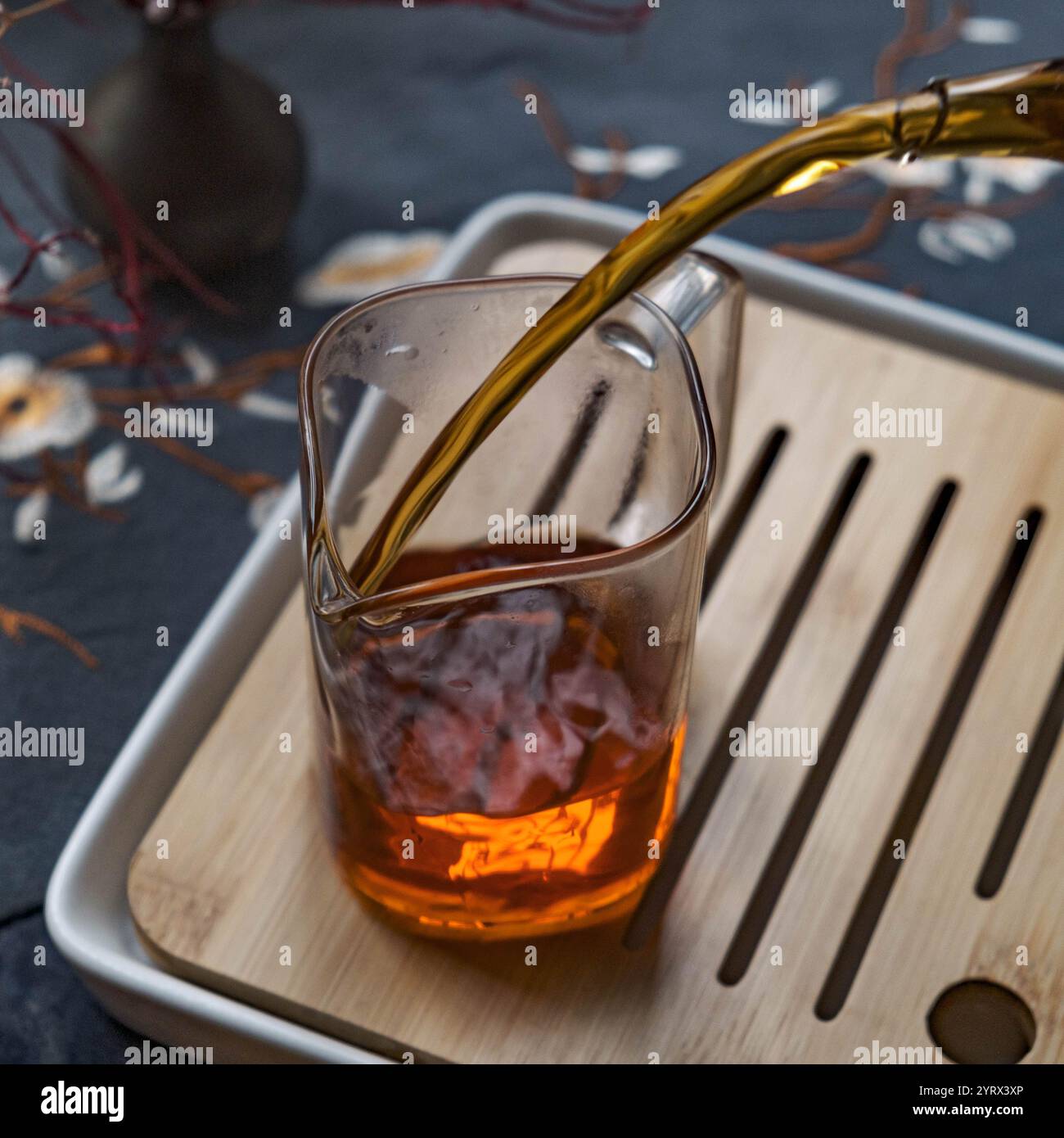 Pouring a delicious cup of Tea into a clear Glass Beaker filled with ...
