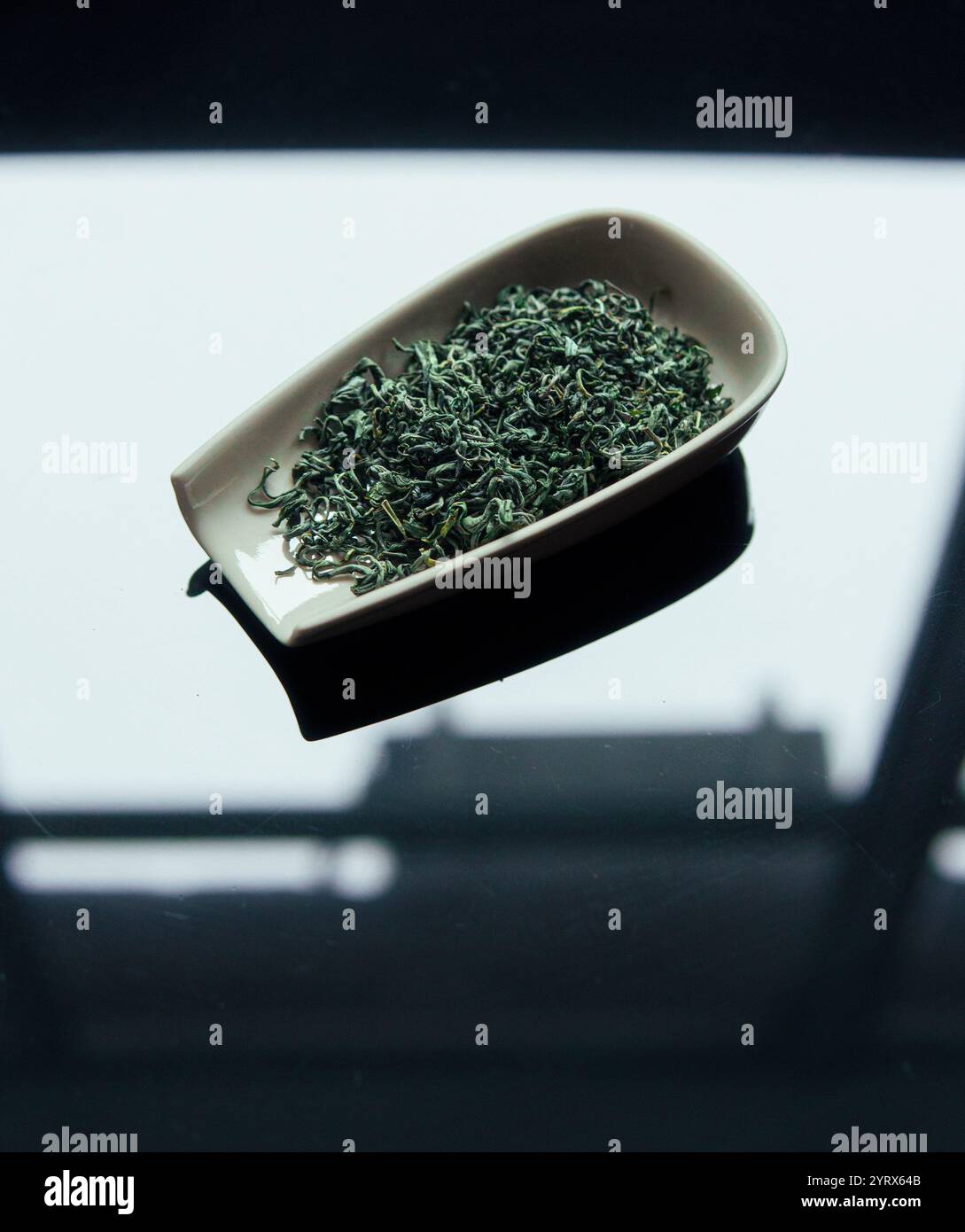 Delicate Green Tea Leaves Beautifully Presented on a Reflective Surface ...
