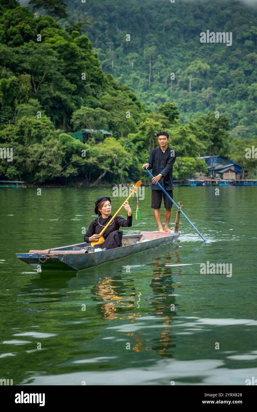 An ethnic Tay man and woman in a boat on Ba Be Lake in Ba Be National ...