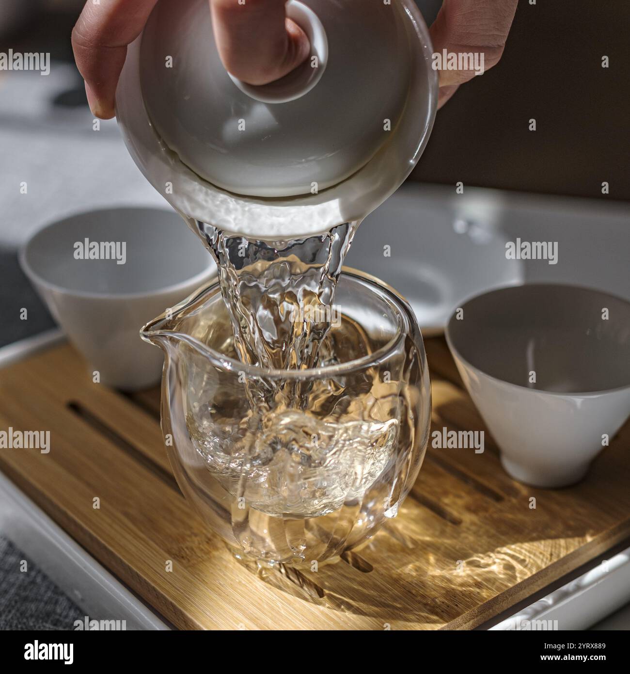 An Elegant Teapot Gracefully Pouring Water into a Clear and Beautiful ...