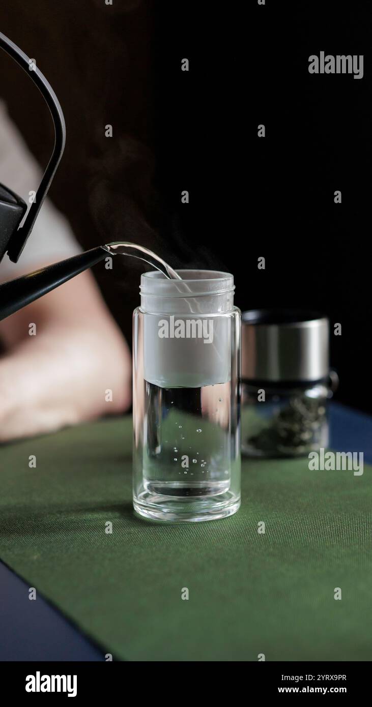 Pouring hot water into a glass container is essential for brewing the ...