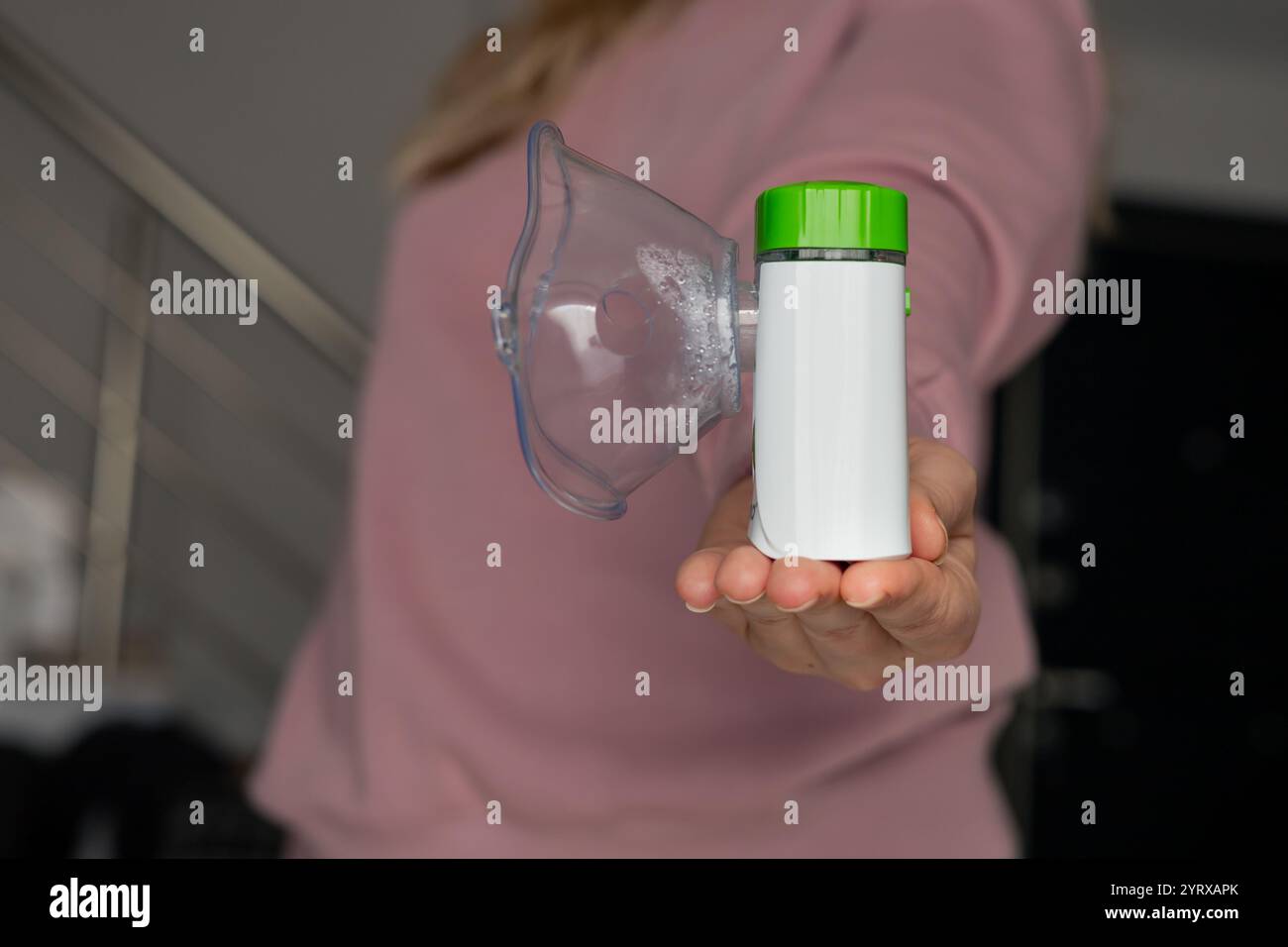 Close-up of female hands holds oxygen mask of nebulizer with steam ...