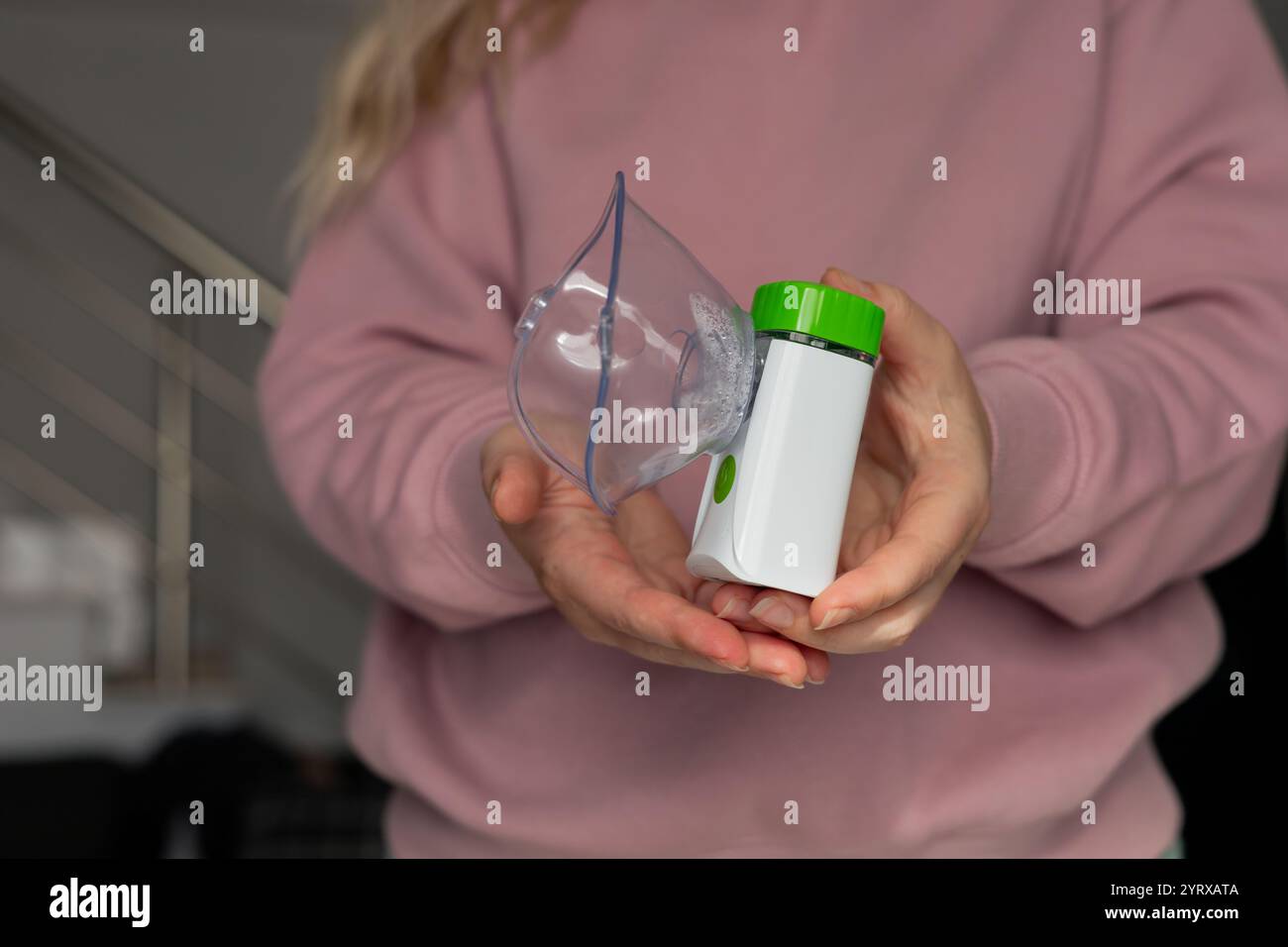 Close-up of female hands holds oxygen mask of nebulizer with steam ...