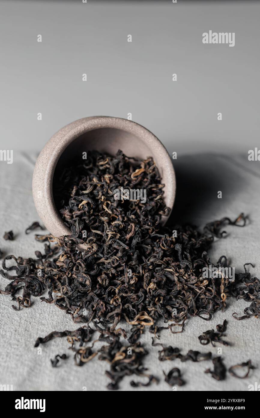 Loose Black Tea Leaves are arranged in a Pot and scattered on a Cloth ...