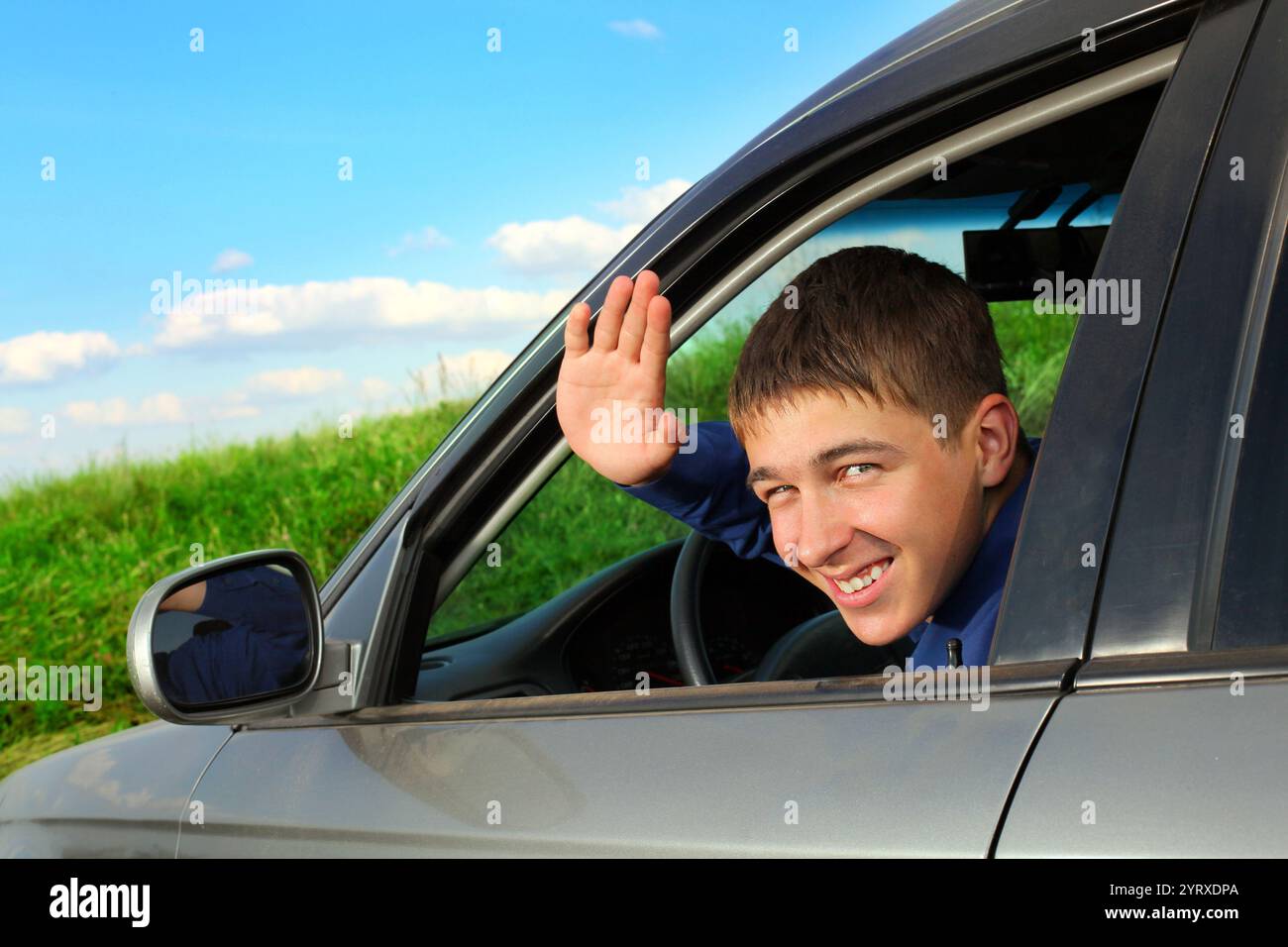 happy young man sitting in the car and wave goodbye Stock Photo - Alamy