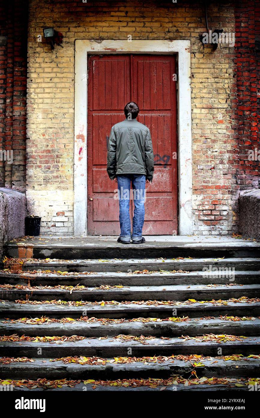 man stand on stairs of an old house with closed door Stock Photo - Alamy