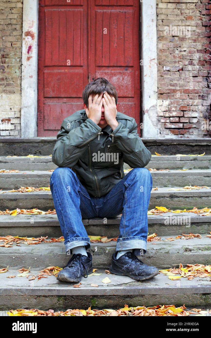 sad young man with hidden face on the old house background Stock Photo ...