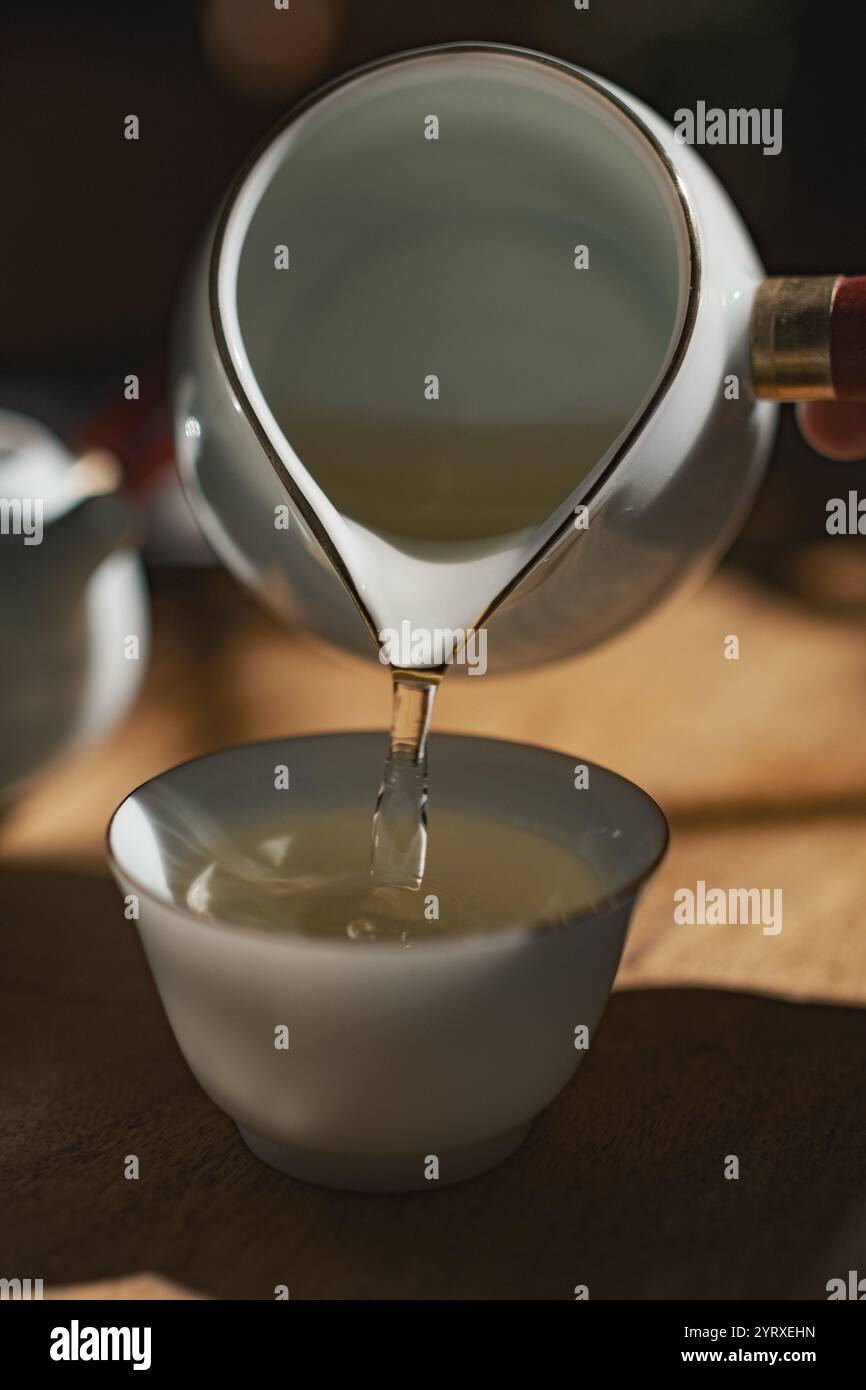 Pouring a comforting cup of tea into a beautiful fine ceramic cup ...