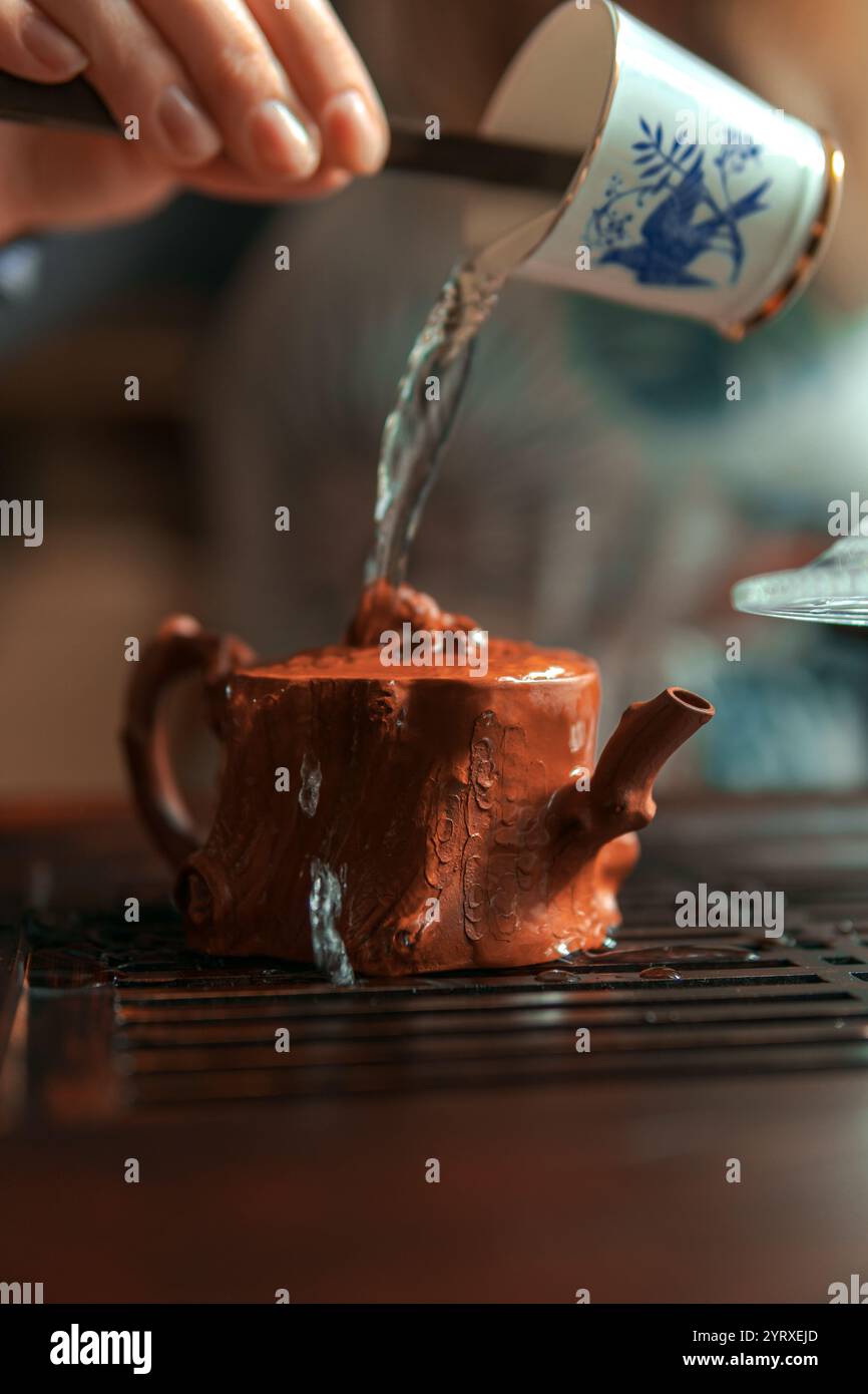 Pouring water carefully into a beautiful, miniature teapot creates a ...