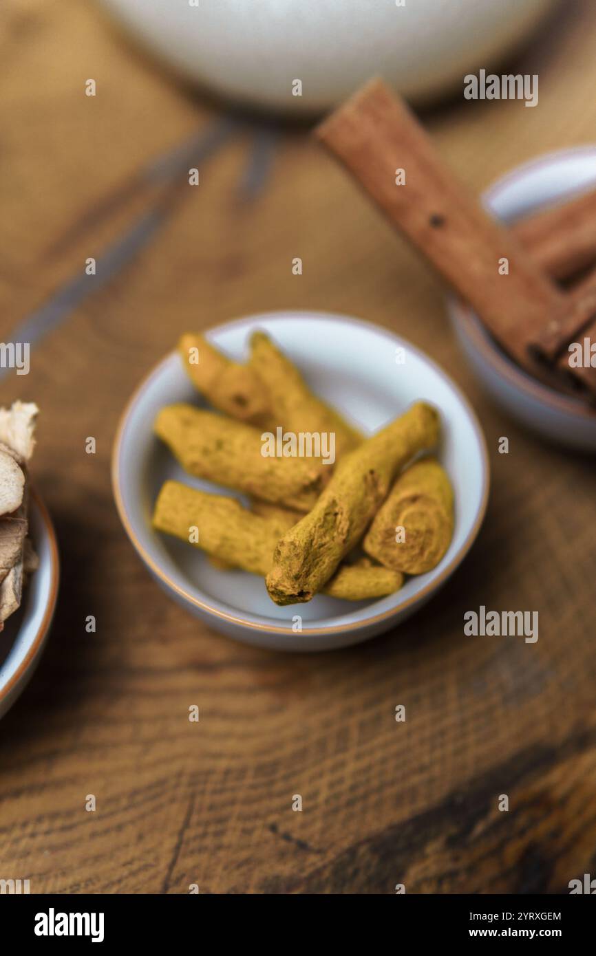 Fresh Turmeric Roots and Cinnamon Sticks beautifully arranged on Rustic ...
