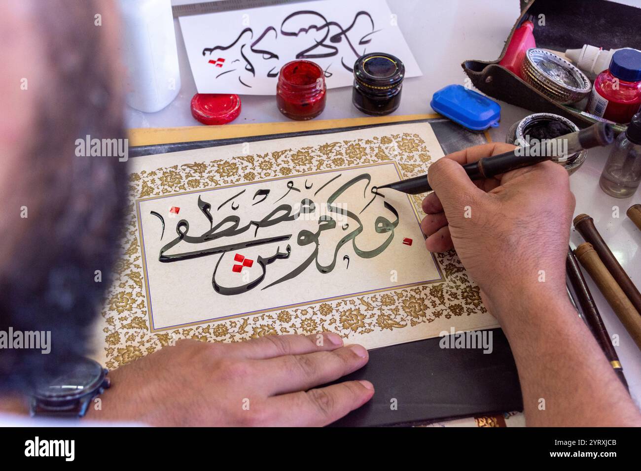 Male Arab calligraphist writing an Arabic name for a customer in Arabic ...