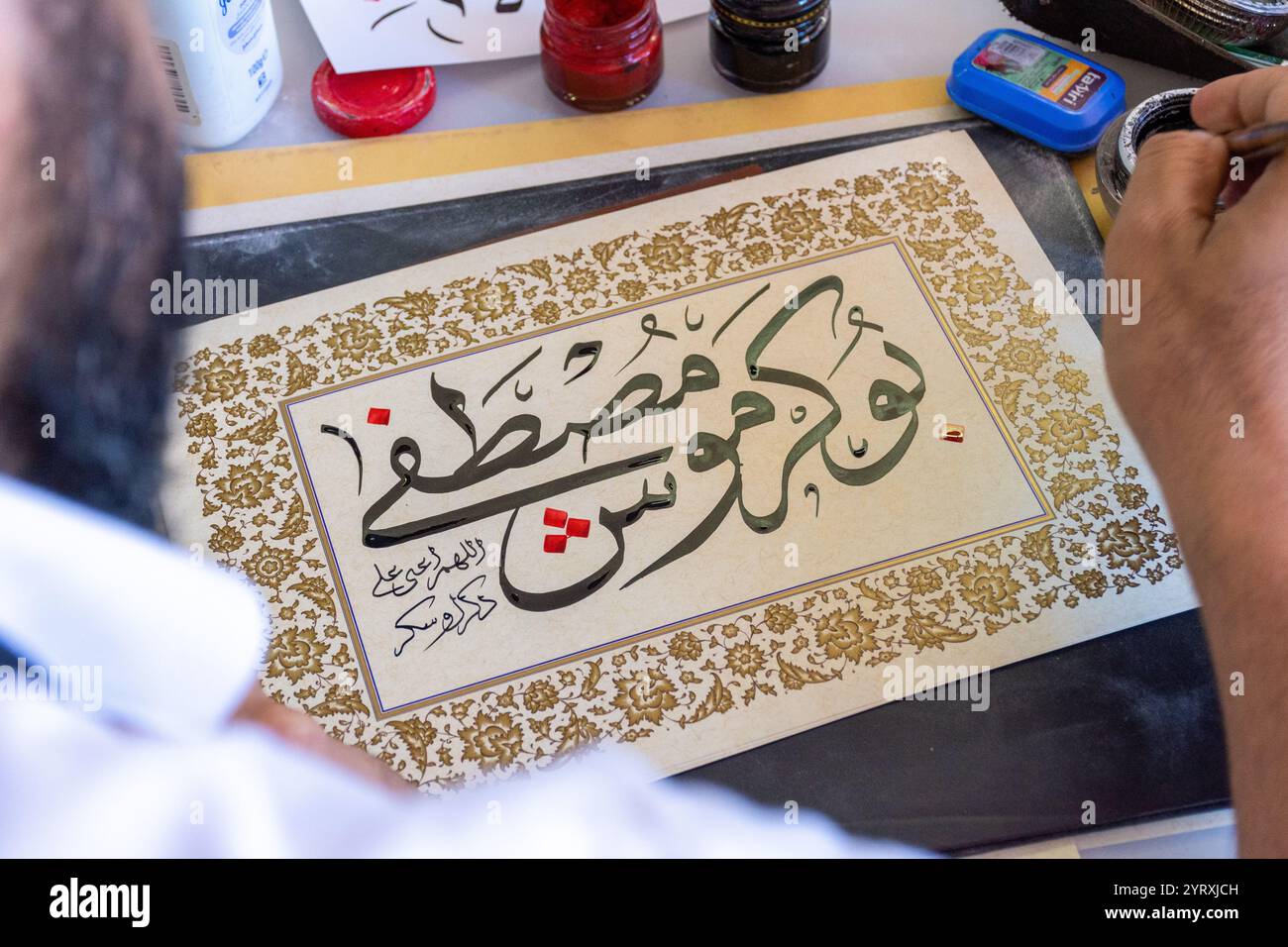 Male Arab calligraphist writing an Arabic name for a customer in Arabic ...
