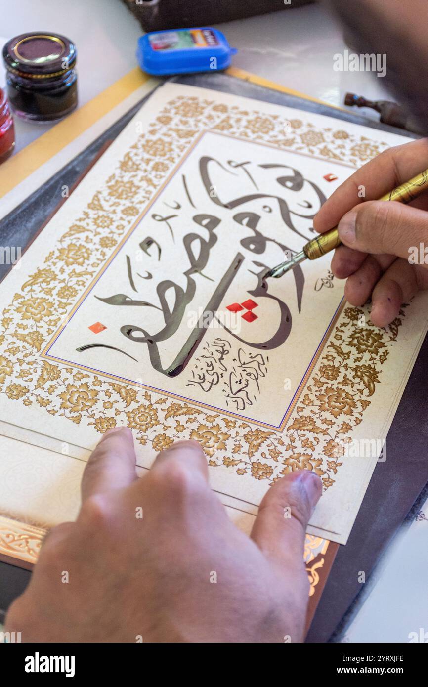 Male Arab calligraphist writing an Arabic name for a customer in Arabic ...