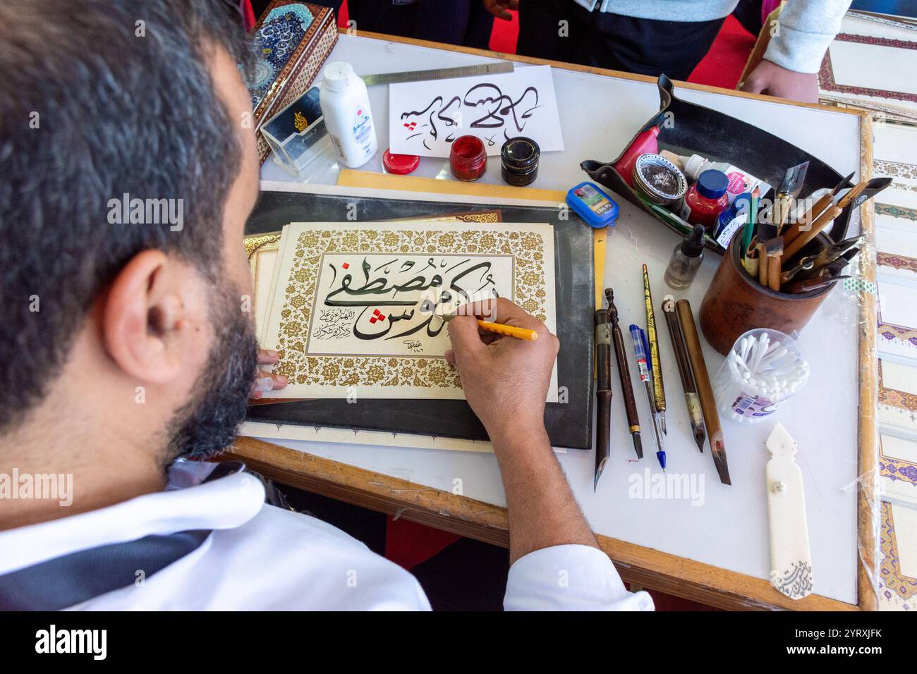 Male Arab calligraphist writing an Arabic name for a customer in Arabic ...