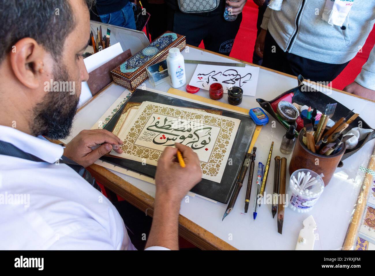 Male Arab calligraphist writing an Arabic name for a customer in Arabic ...