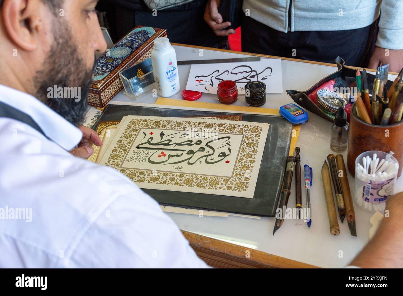Male Arab calligraphist writing an Arabic name for a customer in Arabic ...