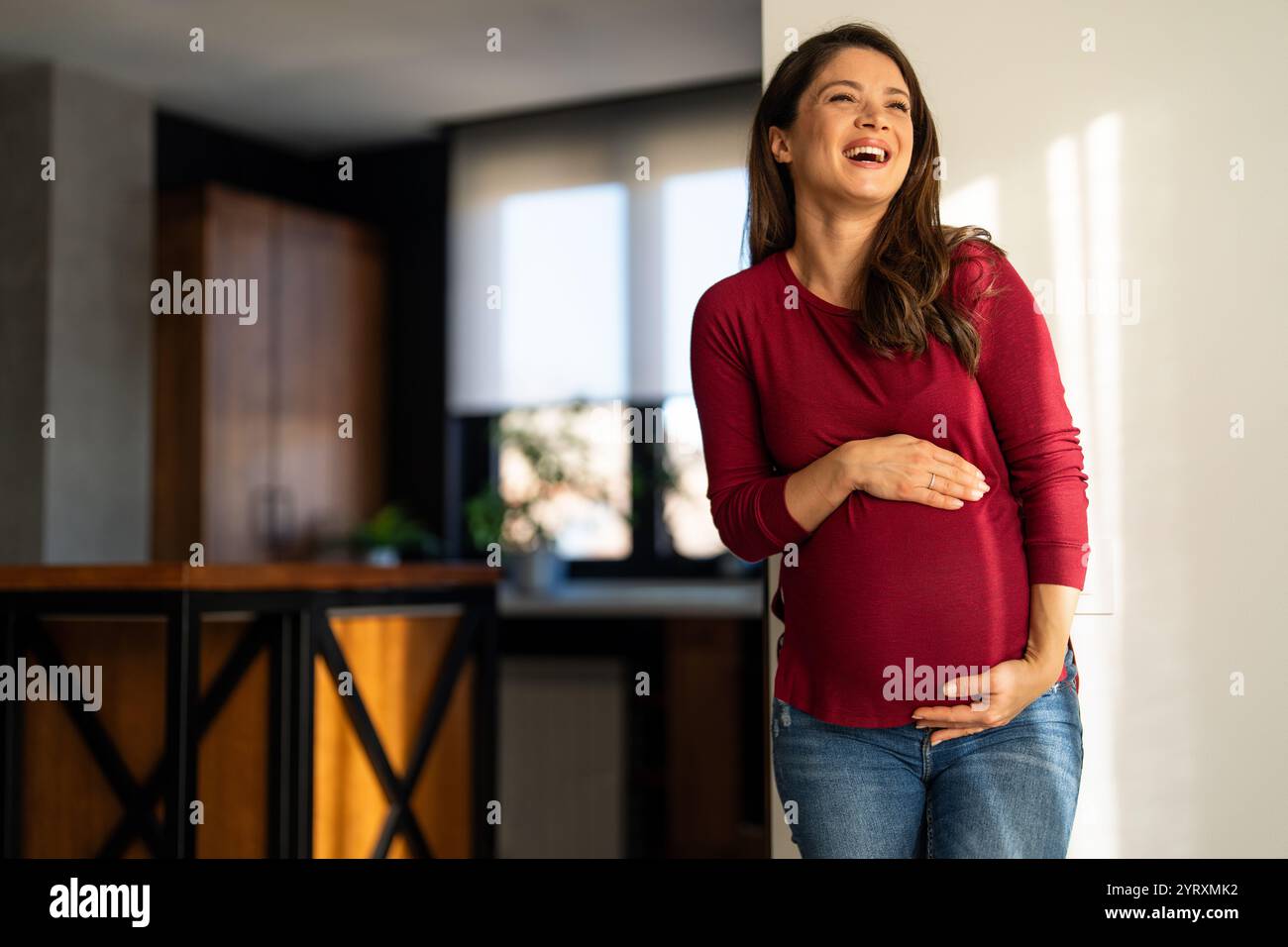 Fit pregnant woman holding hands on her belly, enjoying in the last ...
