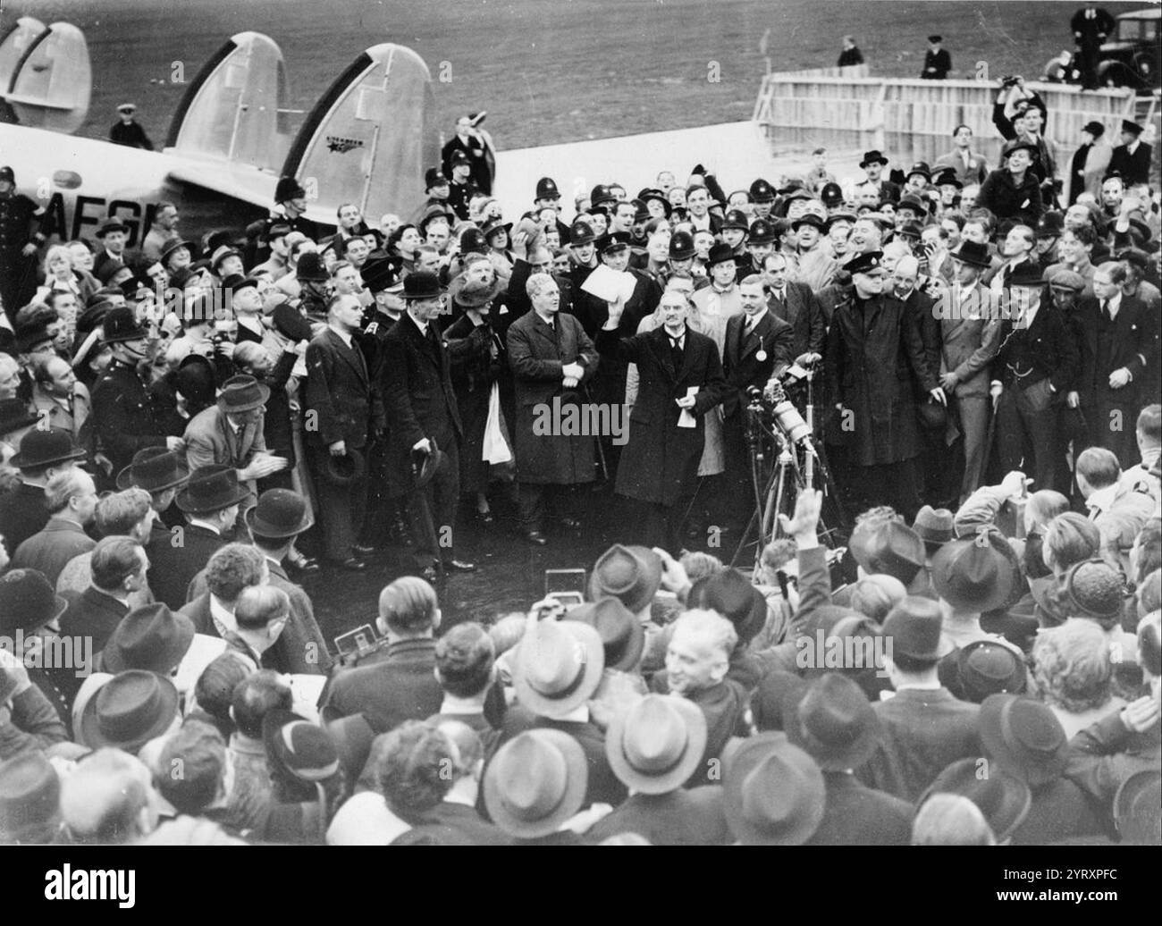 Neville Chamberlain holding the paper containing the resolution to ...