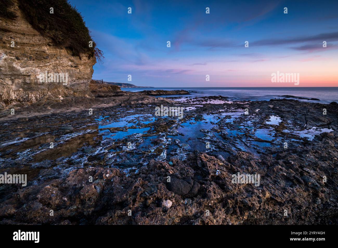 Tide pools reflect the colors of sunset at Crescent Bay Beach ...