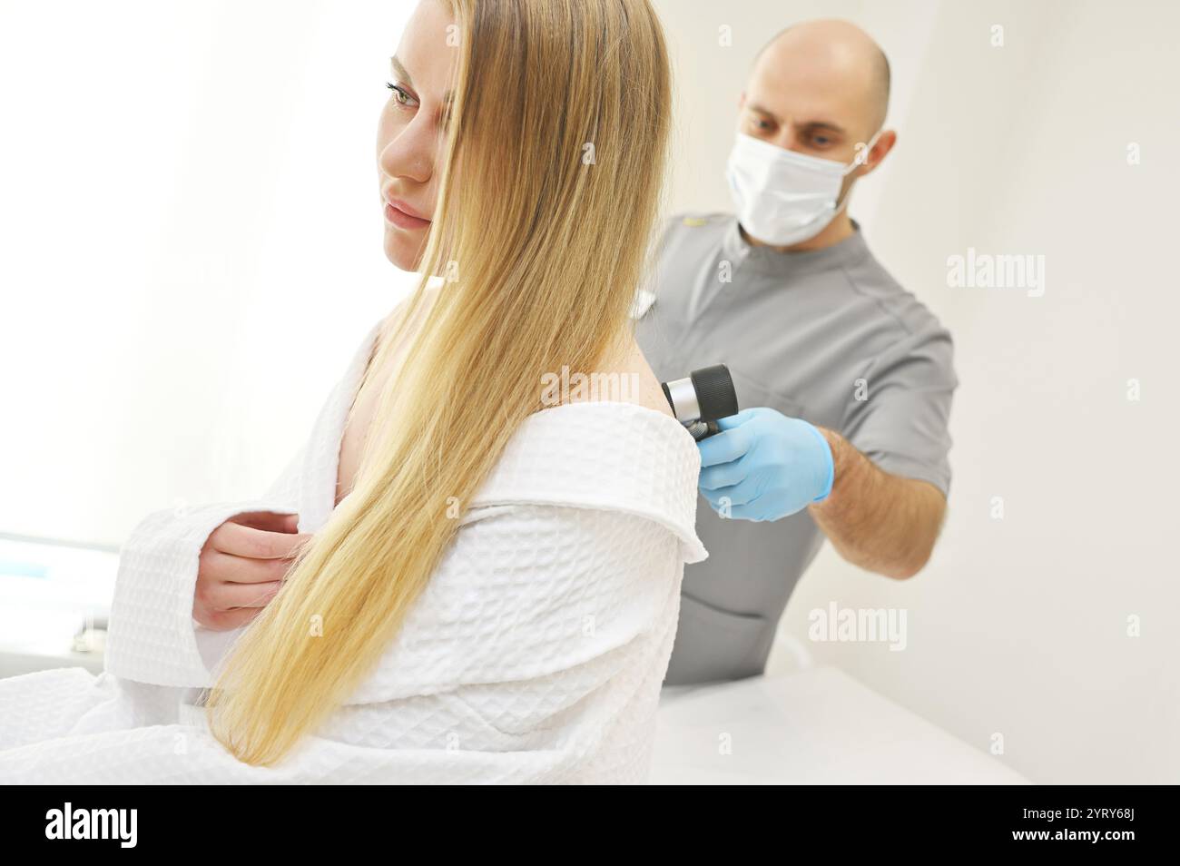 dermatologist oncologist uses a dermatoscope to examine moles and ...