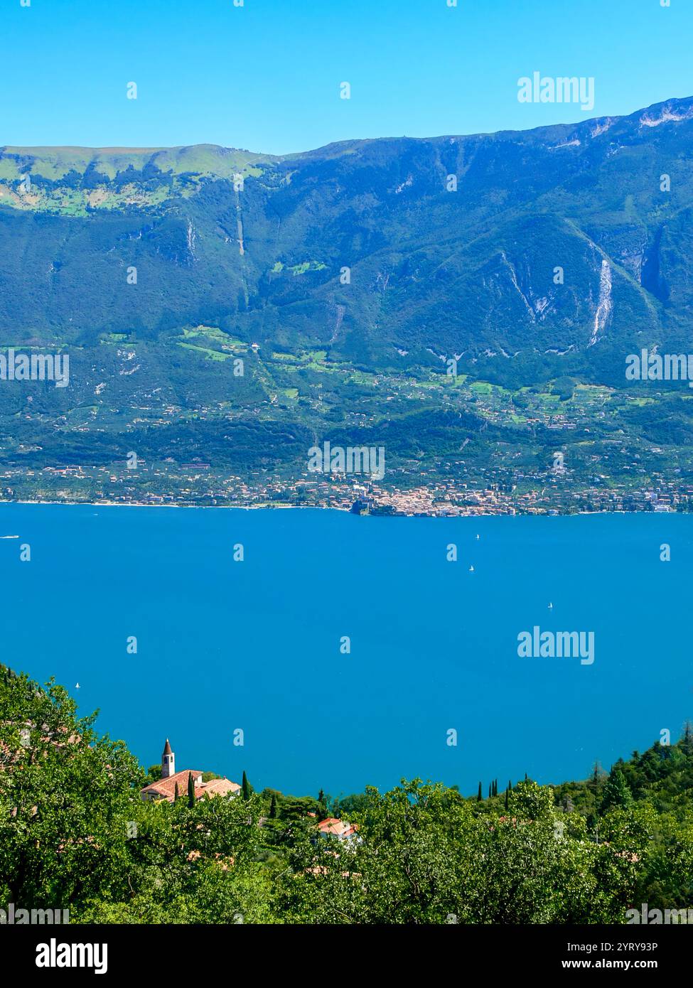 View of Lake Garda and Malcesine from Tremosine. The church of Pieve in ...
