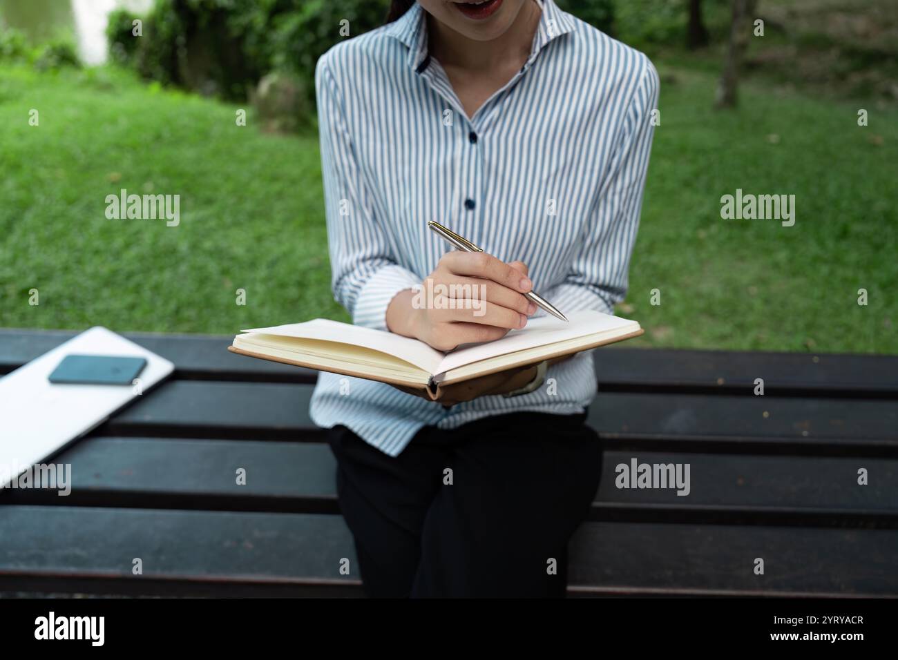 Young Professional Reading and Working Outdoors in a Park Setting with ...