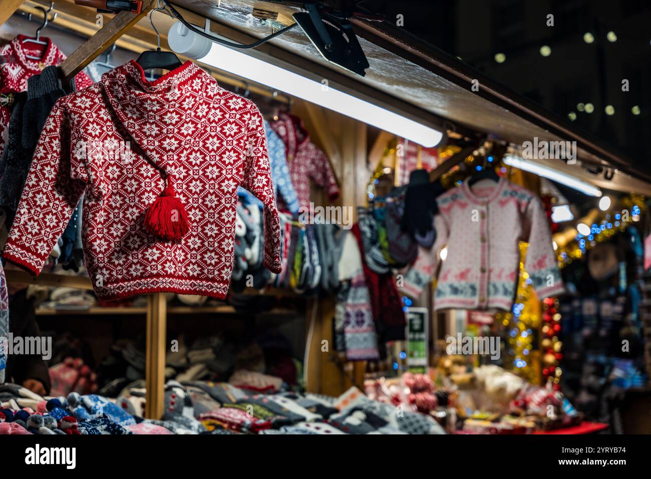 Red knitted sweater on display at a festive market stall Stock Photo ...