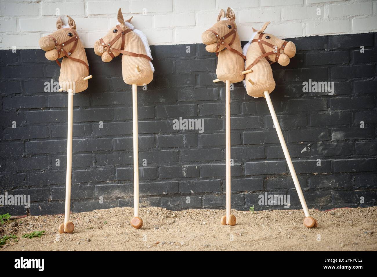 Toy hobby horses lined up against a wall, evoking nostalgia, childhood ...