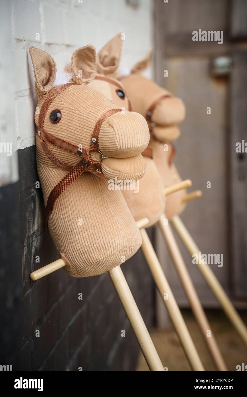 Toy hobby horses lined up against a wall, evoking nostalgia, childhood ...