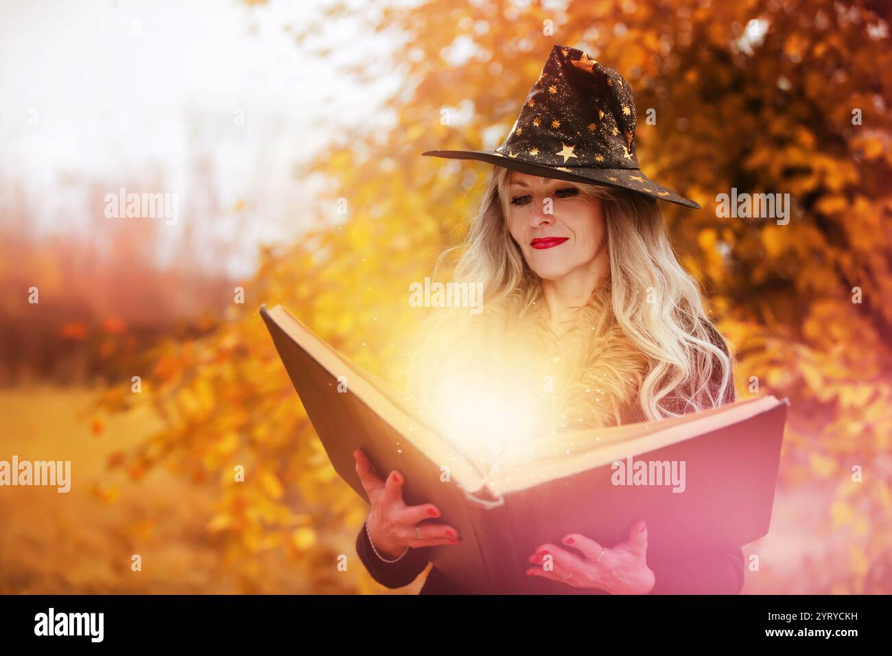 Halloween a woman with a magic spell book in a witch hat is conjuring ...