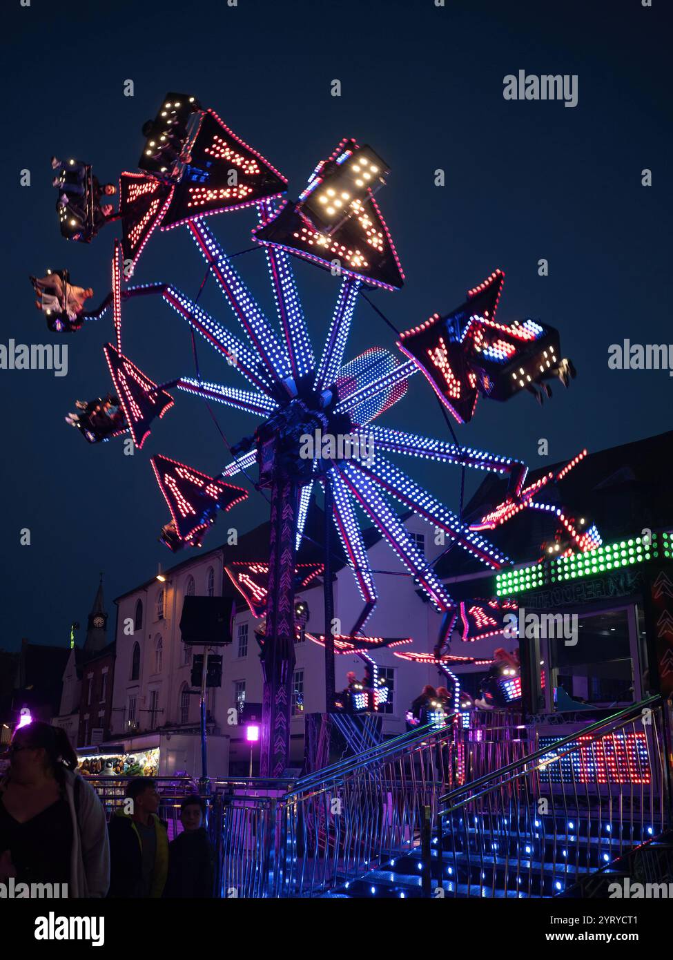 A brightly-lit funfair ride at night Stock Photo - Alamy