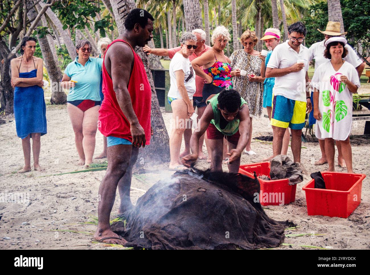 Fijian men preparing a lovo or earth oven, for cooking a traditional ...