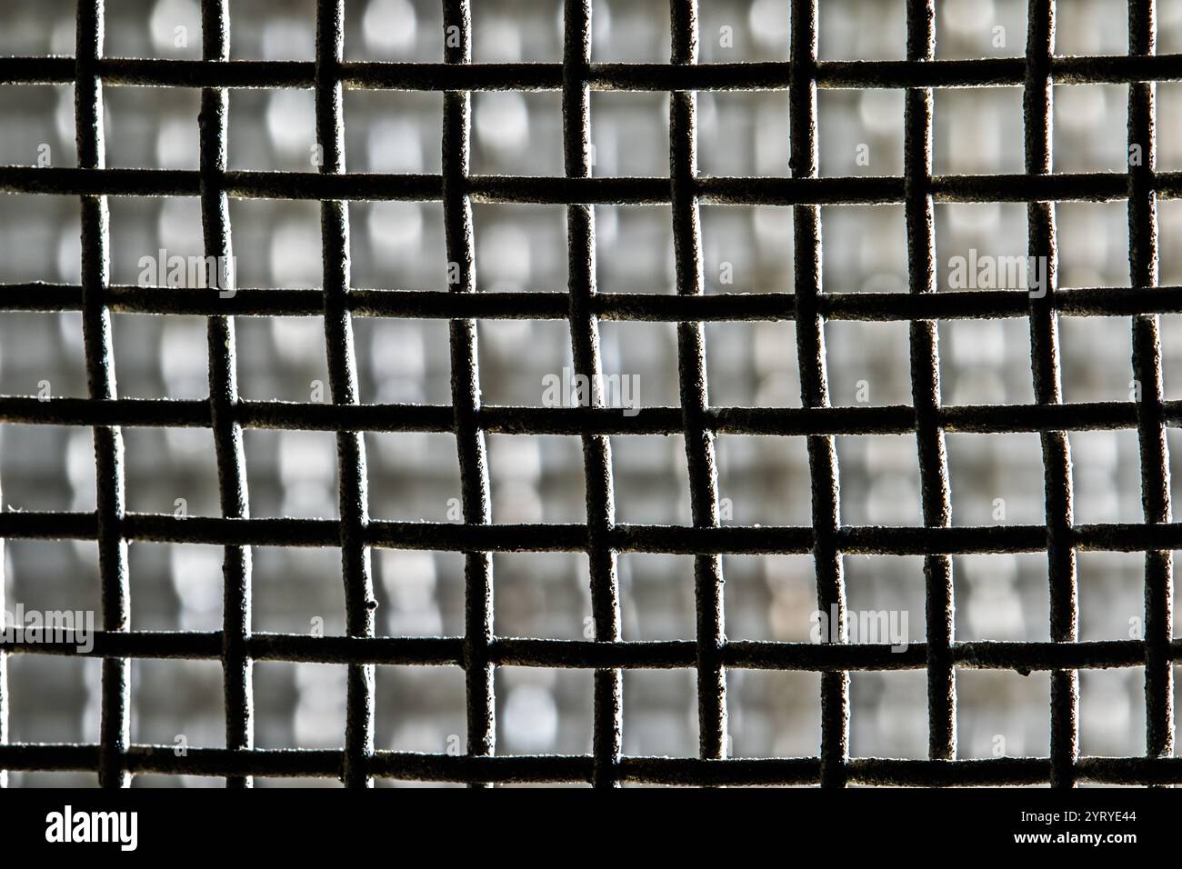 Metal grid forming a repetitive pattern with a blurred background Stock ...