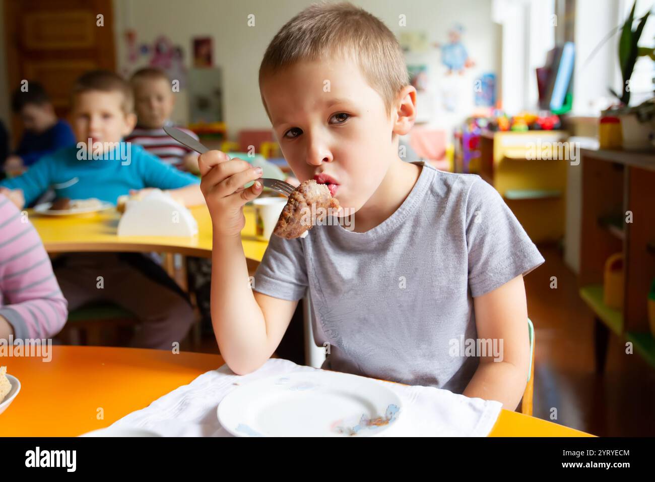 A little boy is eating in kindergarten. Nutrition for small children ...