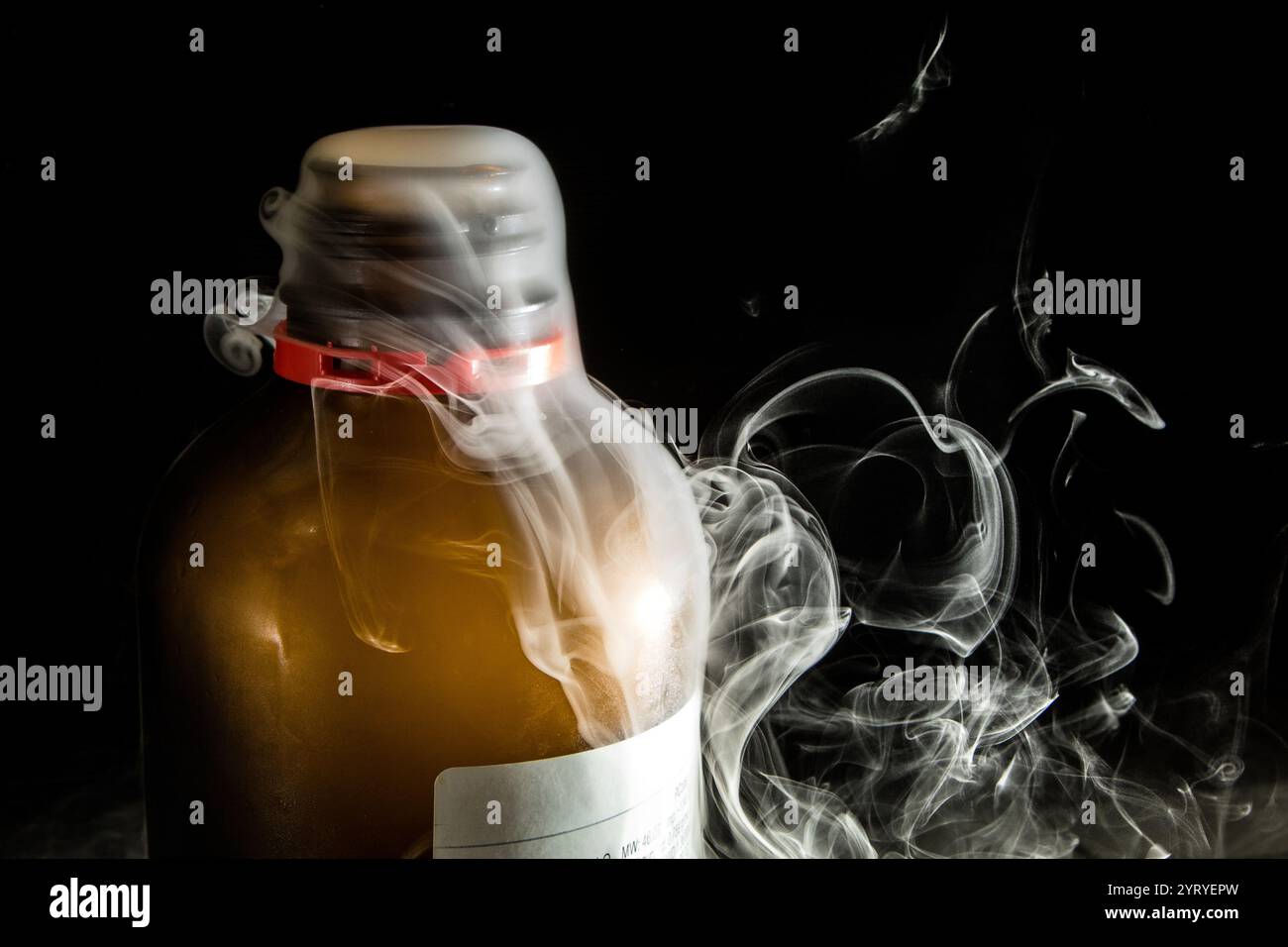 White smoke is escaping from a brown reagent bottle with a red cap in a ...