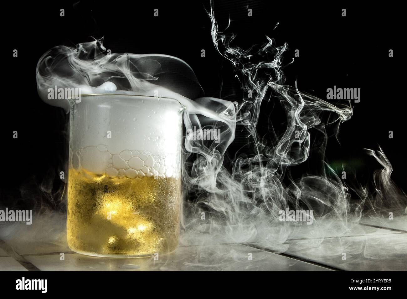 White smoke is coming out of a beaker containing a yellow chemical ...