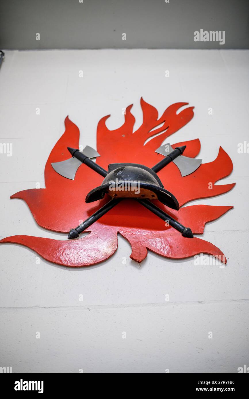 Fire department emblem featuring crossed axes and helmet on a stylized ...