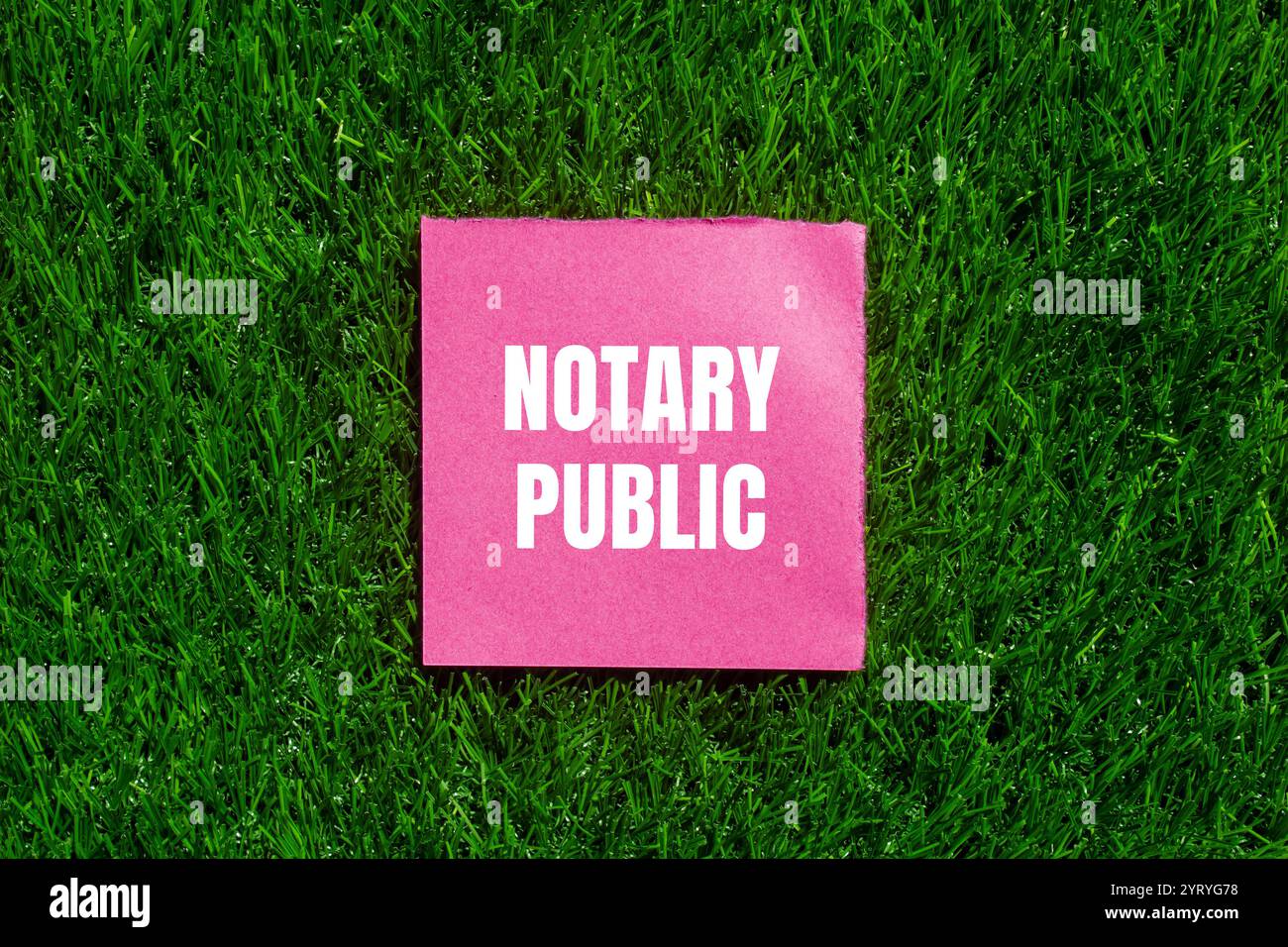Notary public message written on ripped torn pink paper with green ...