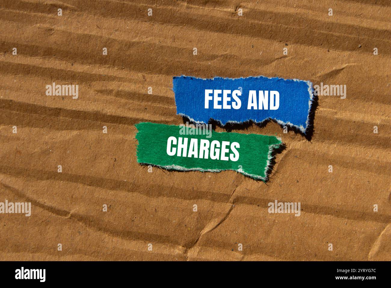 Fees and charges message written on ripped torn paper pieces with ...