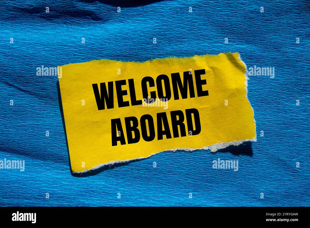 Welcome aboard message written on ripped torn yellow paper piece with ...