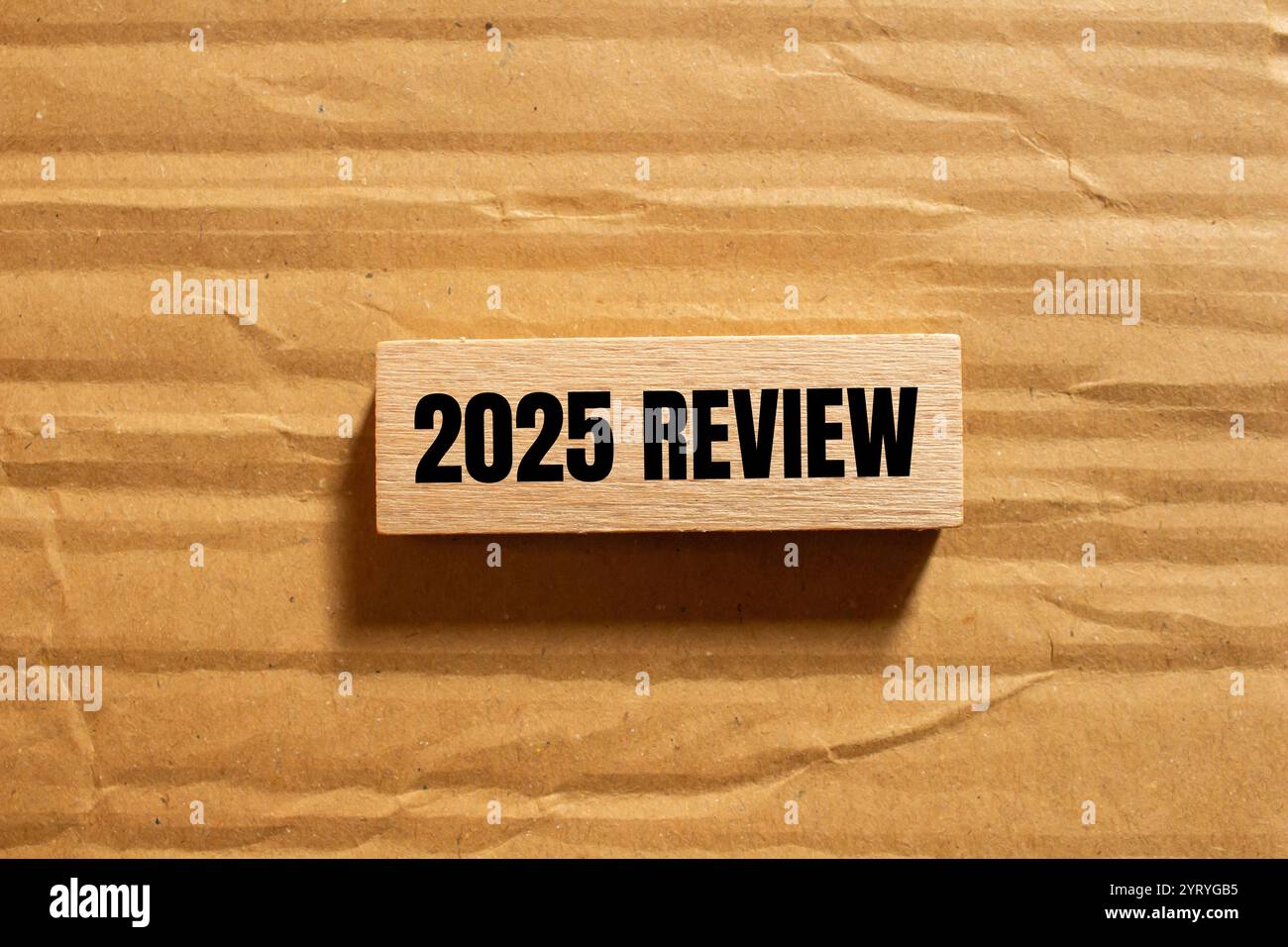 2025 review message written on wooden block with cardboard background. Conceptual 2025 review ...