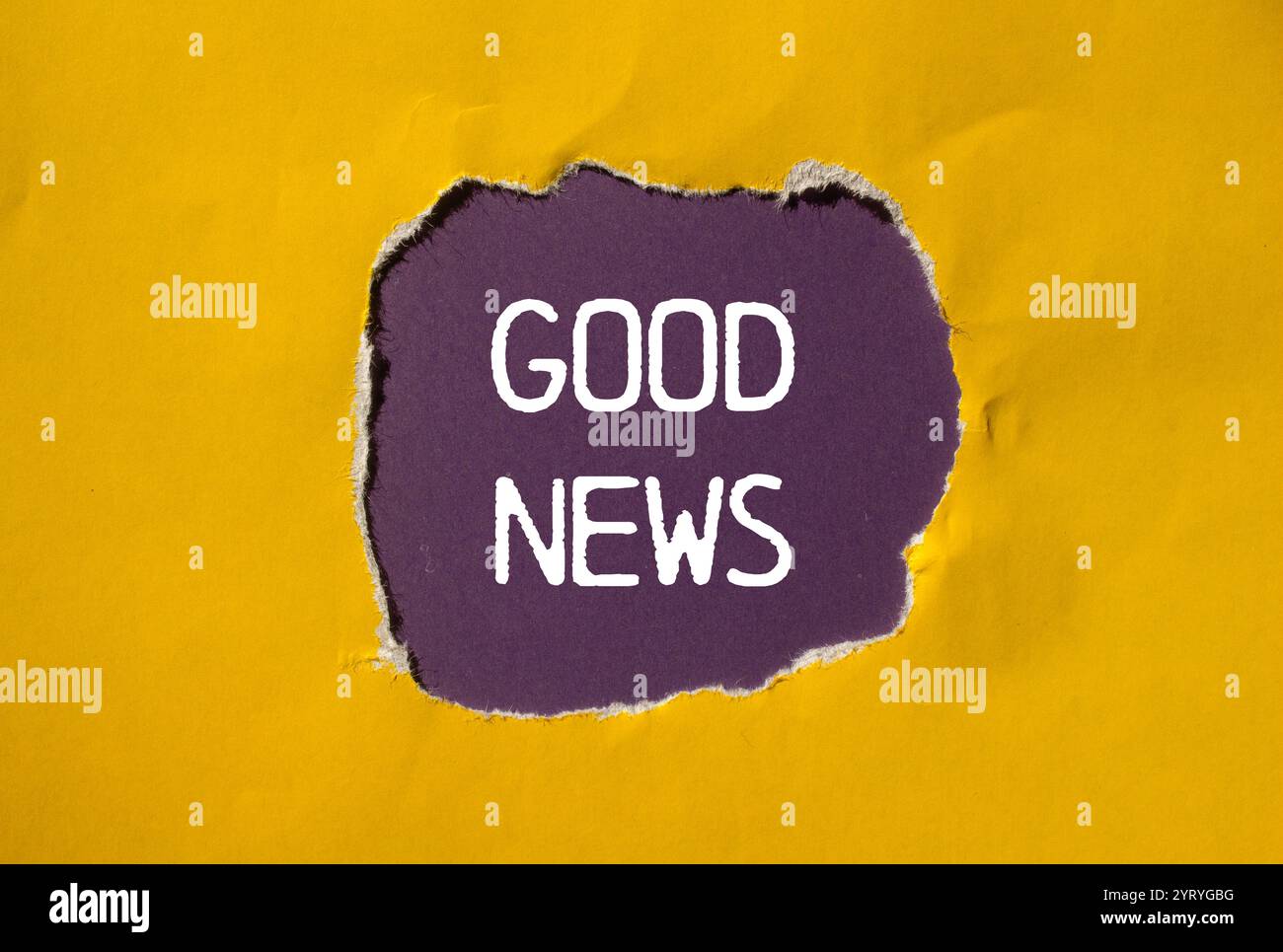 Good news message written on ripped torn yellow paper with purple ...