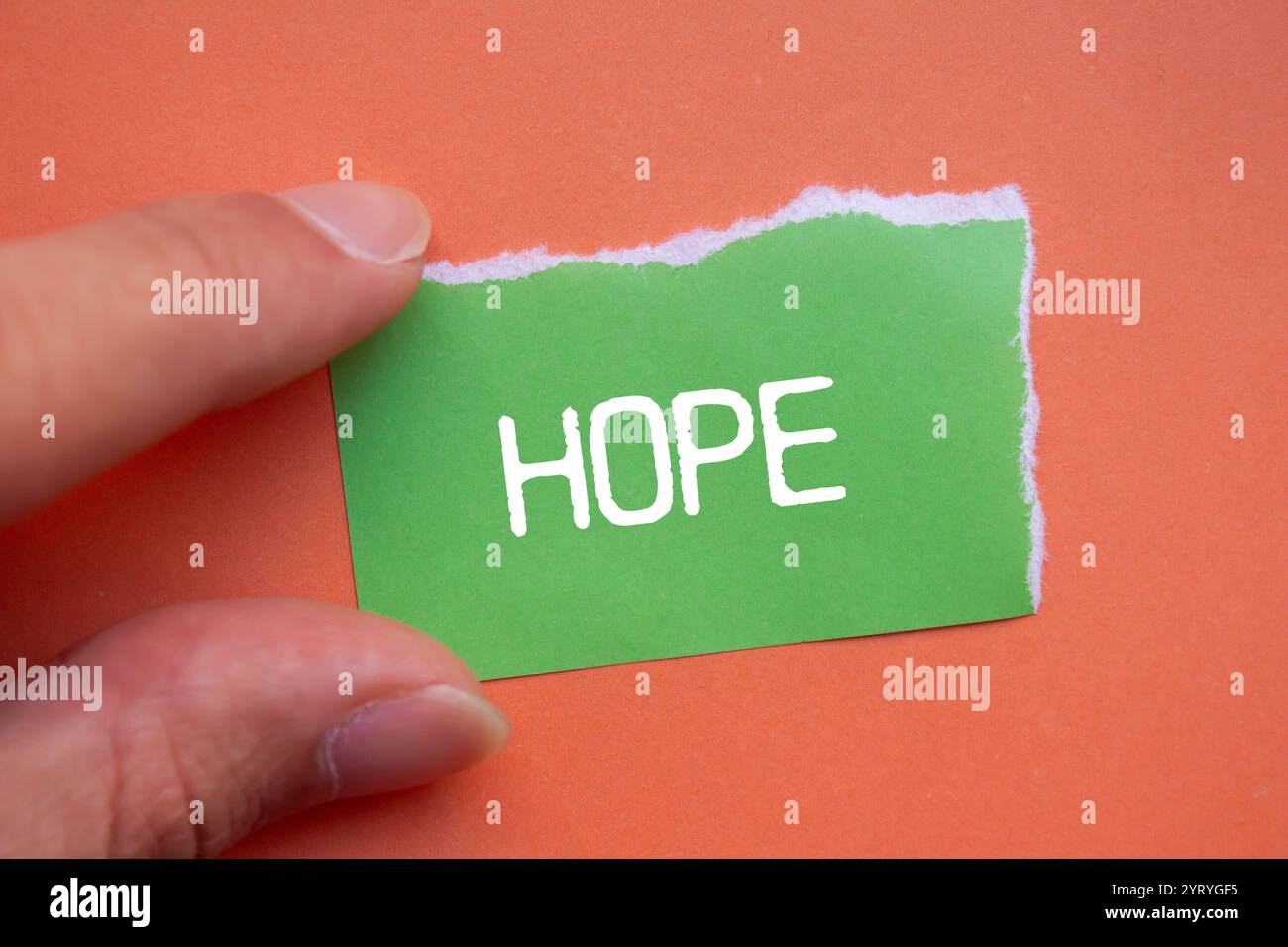 Hope message written on ripped green torn paper with orange background. Conceptual hope symbol ...