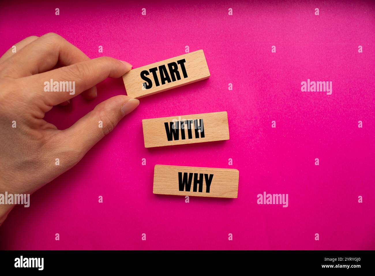 Start with why message written on wooden blocks with pink background ...