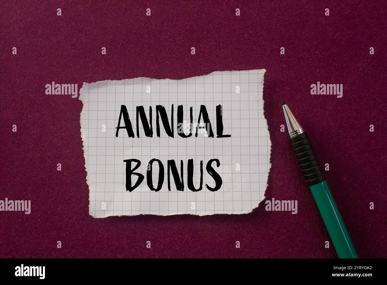 Annual bonus message written on ripped torn paper piece with purple ...