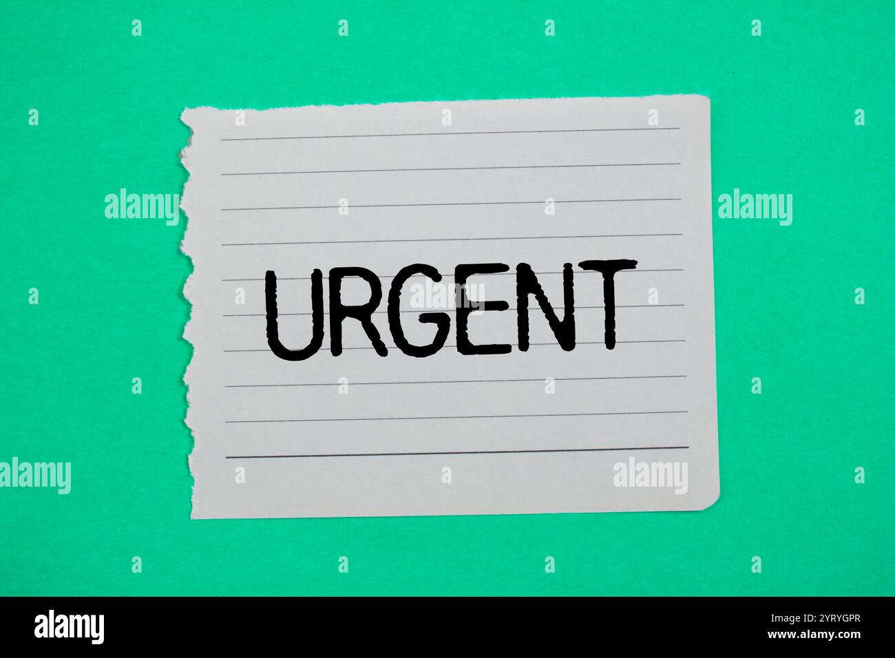 Urgent message written on ripped torn paper piece with green background ...