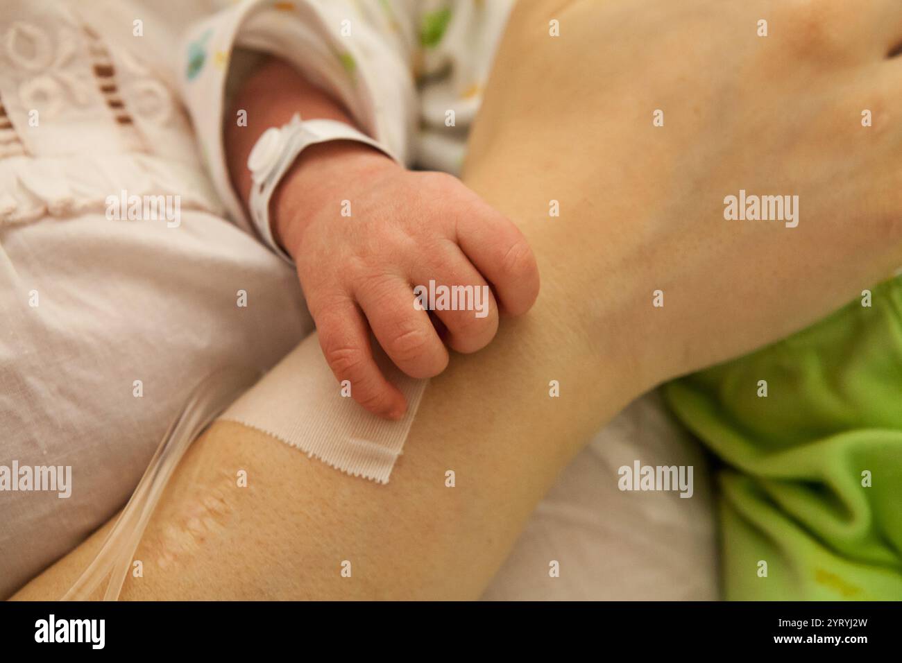 Newborn baby hand gently touching mother's arm, showing connection and ...
