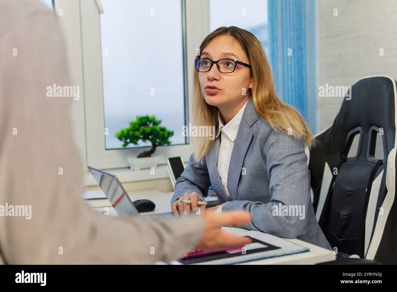 The businesswoman looks at her colleagues about work with displeasure ...