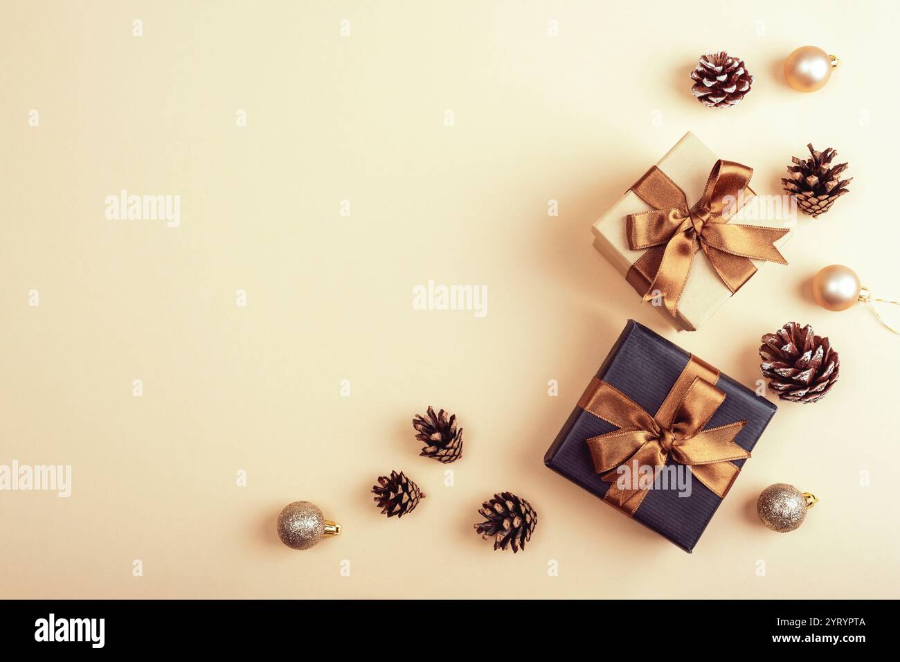 Elegant gift boxes with golden ribbons surrounded by pine cones and ...