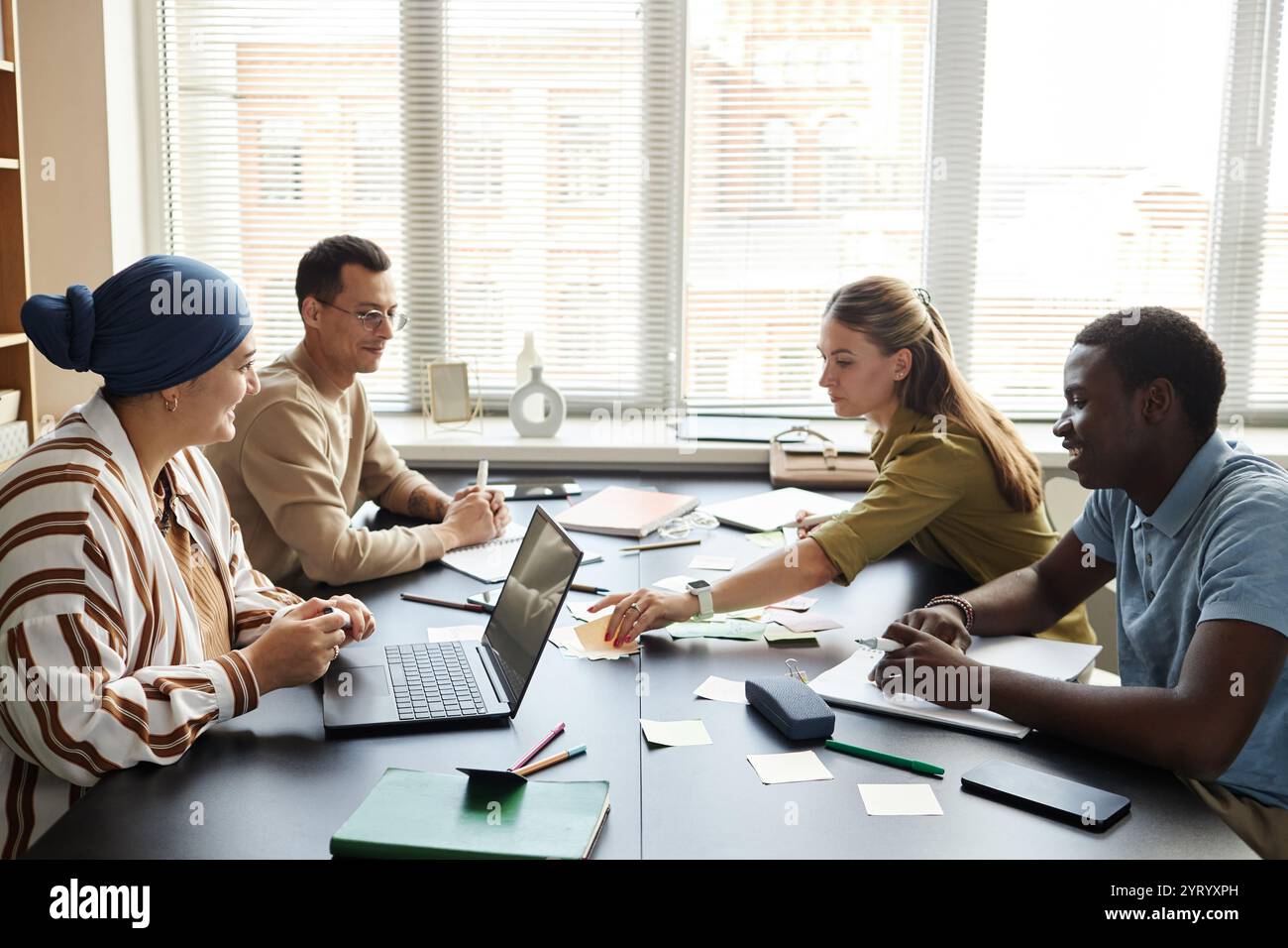 Side view of female English teacher reaching out to take stickers with new words, while playing ...